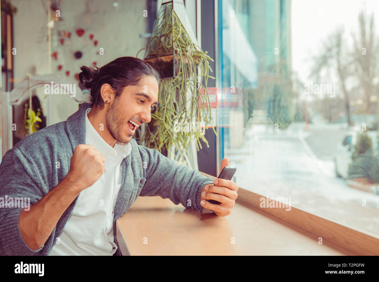 Excited man checking news on smart phone pumping fist. Closeup portrait ...