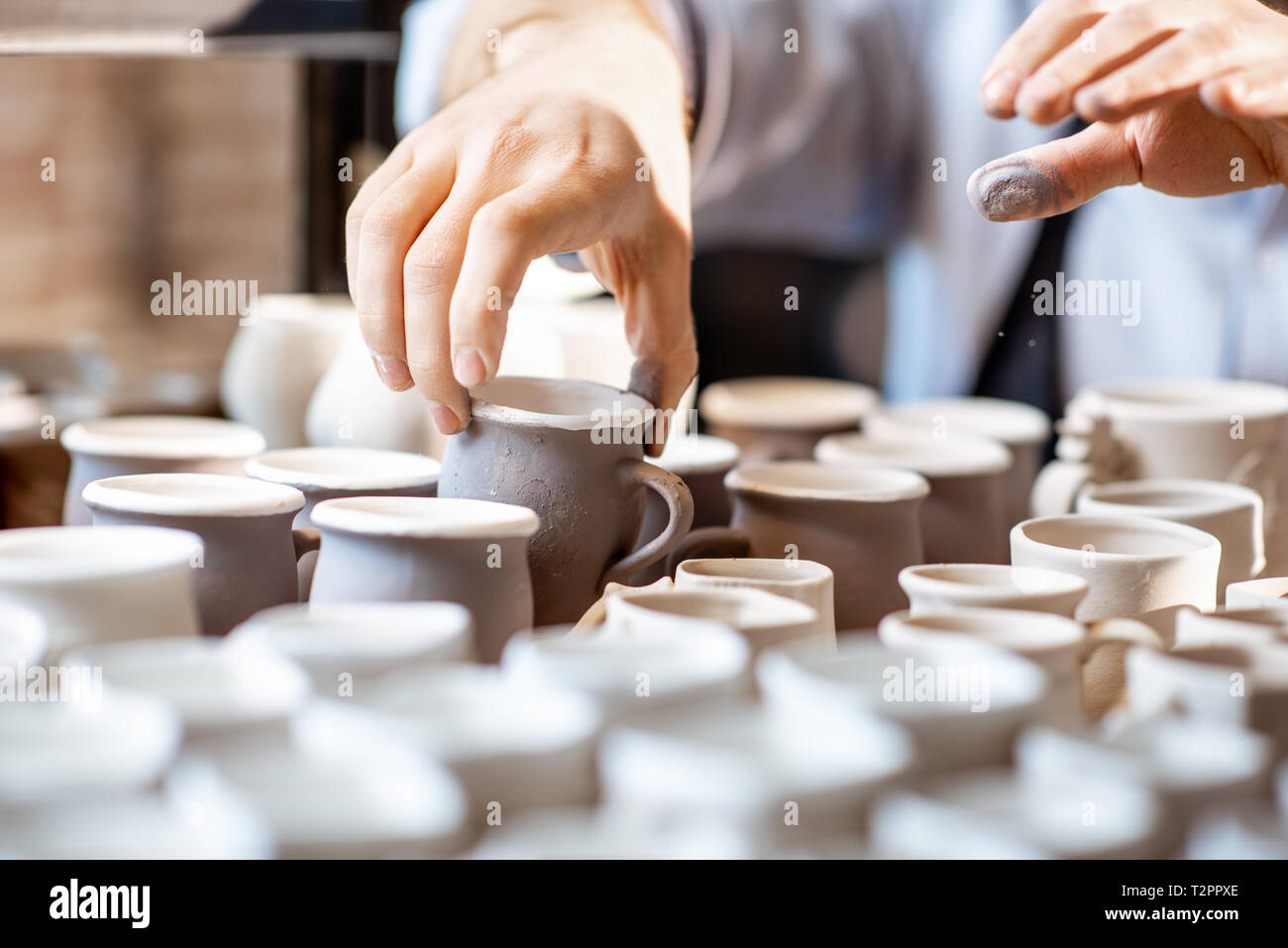 Man taking clay jugs at the warehouse of the pottery shop, close-up ...