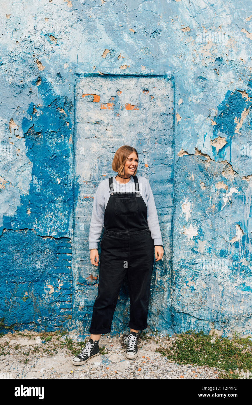 Portrait of woman, weathered wall in background Stock Photo - Alamy