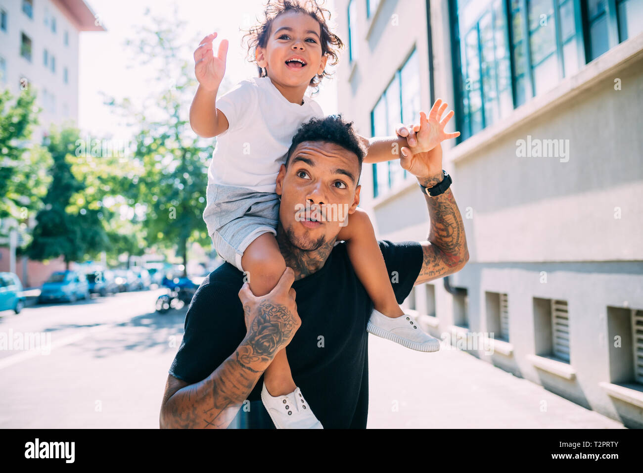 Father and son playing piggyback ride on sidewalk Stock Photo - Alamy