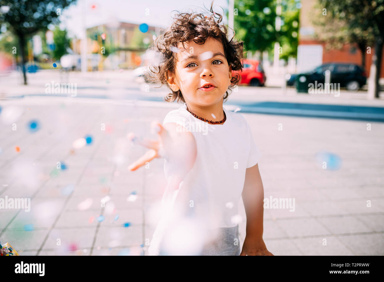 Toddler playing with confetti in park Stock Photo - Alamy