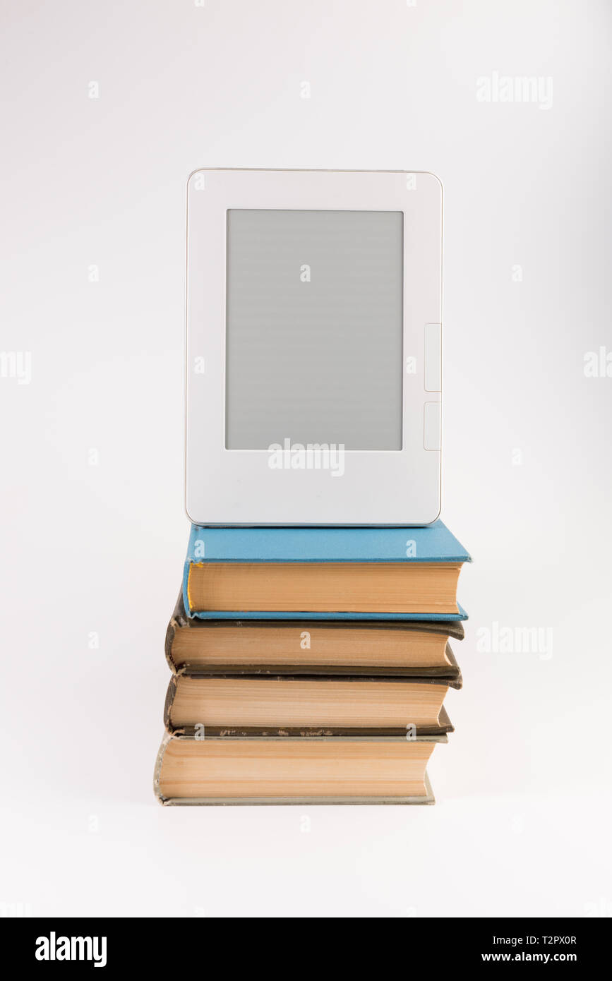 Electronic book on the top of the stack of regular old books isolated ...