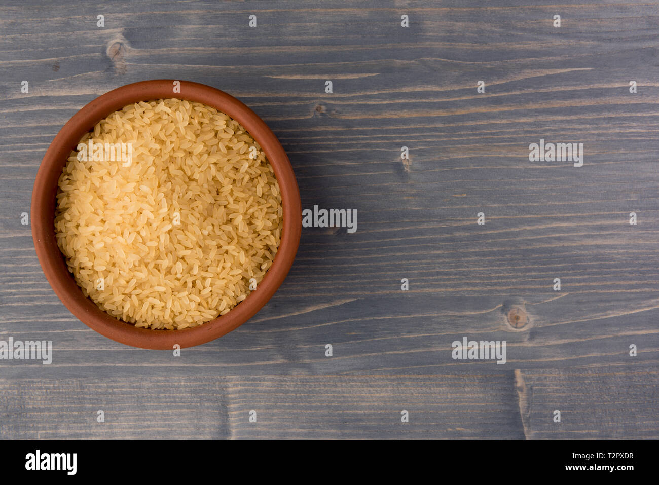 white rice in bowl on wooden table background Stock Photo - Alamy