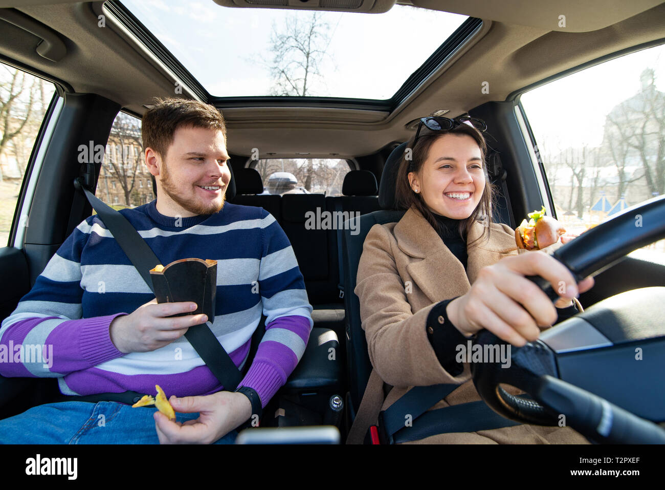 young couple eating fast food in car. modern rhythm lifestyle Stock ...