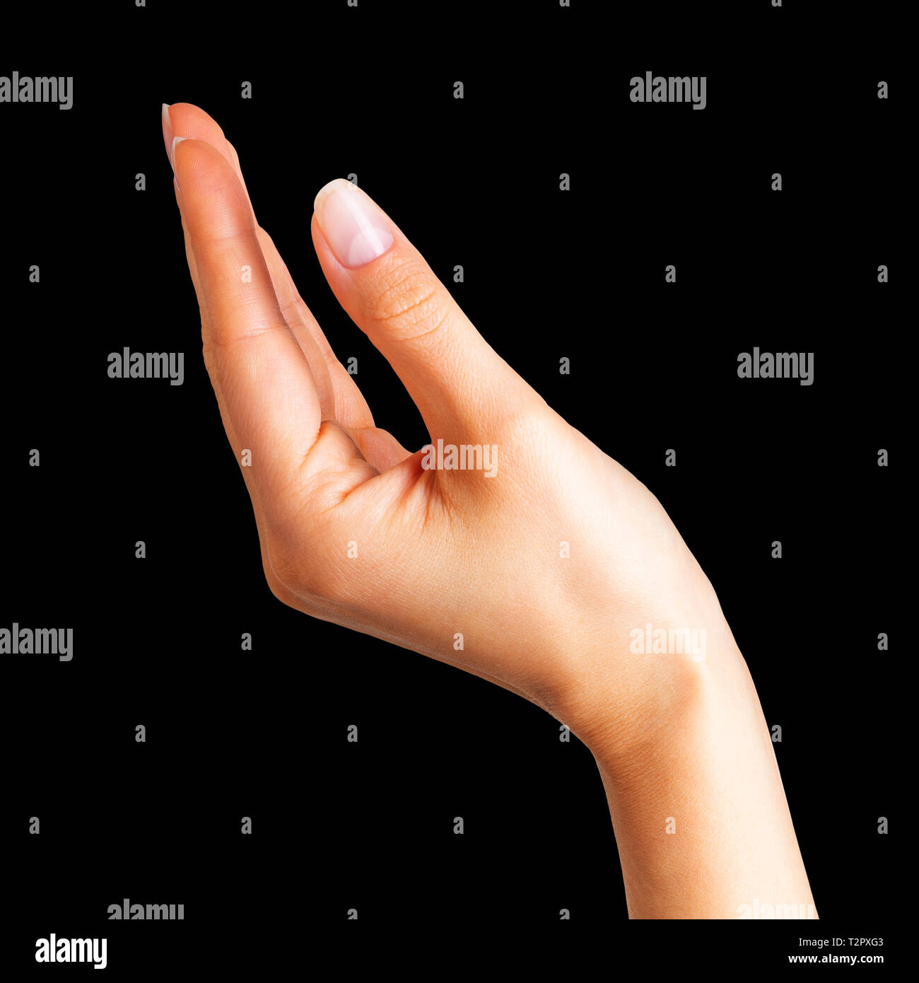 Woman hand holding something with two fingers on black background ...