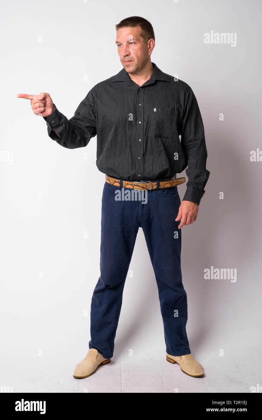 Studio shot of macho mature businessman looking strong and muscular ...