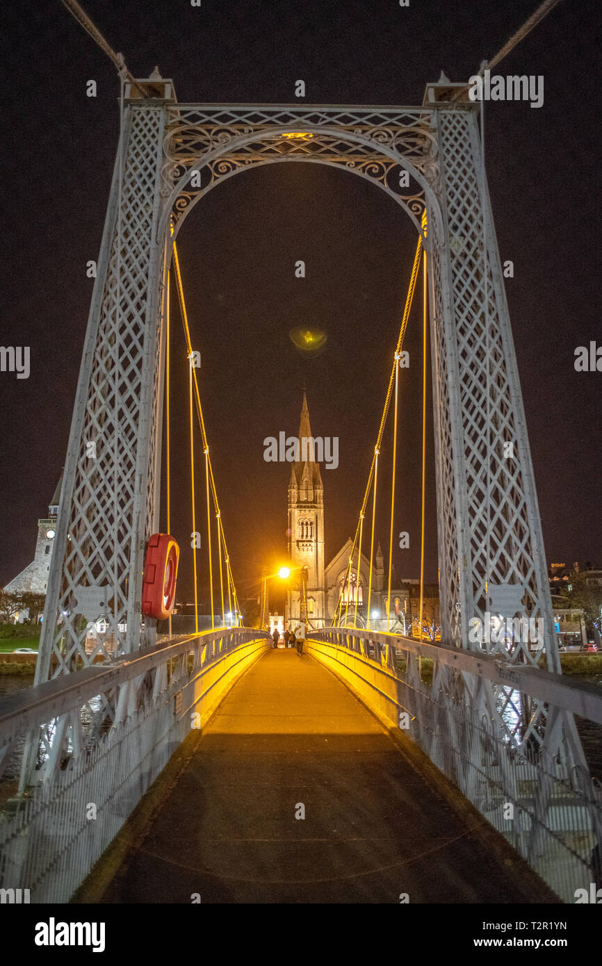 People walk across a pedestrian bridge in Inverness, Scotland Stock ...