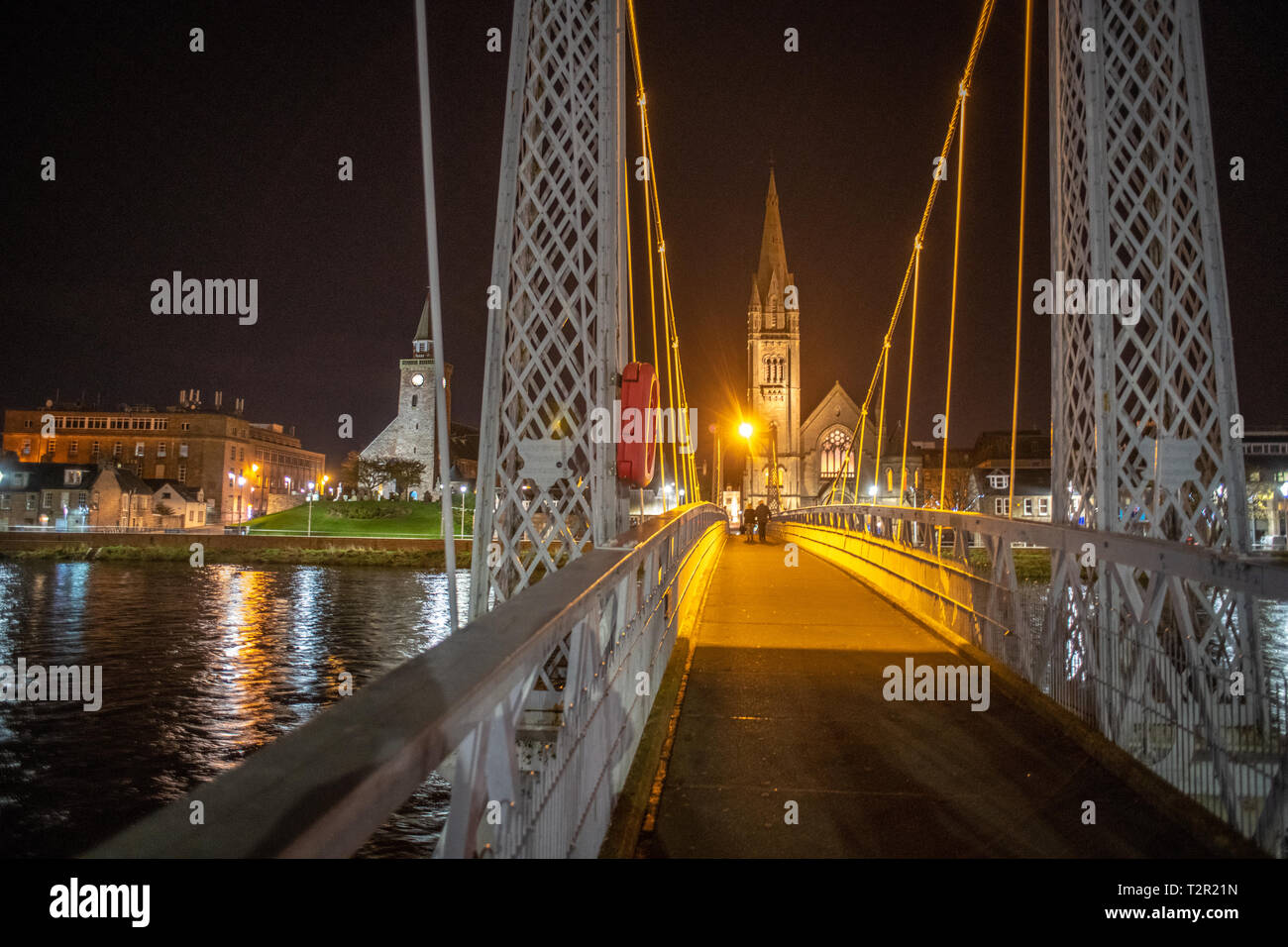 People walk across a pedestrian bridge in Inverness, Scotland Stock ...