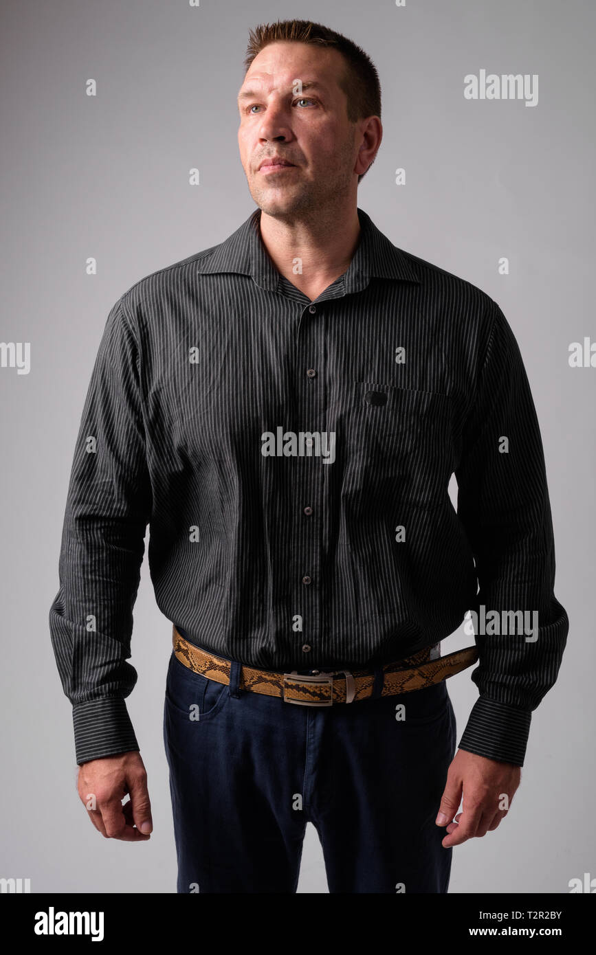 Studio shot of macho mature businessman looking strong and muscular ...