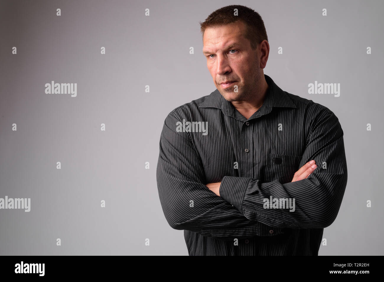 Studio shot of macho mature businessman looking strong and muscular ...