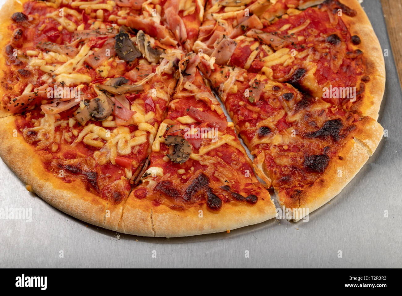 Pizza from the supermarket re-heating in the oven on a wooden table ...