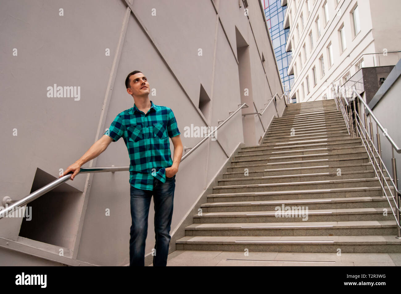 A young man stands on a big ladder and raises his thumb up Stock Photo ...