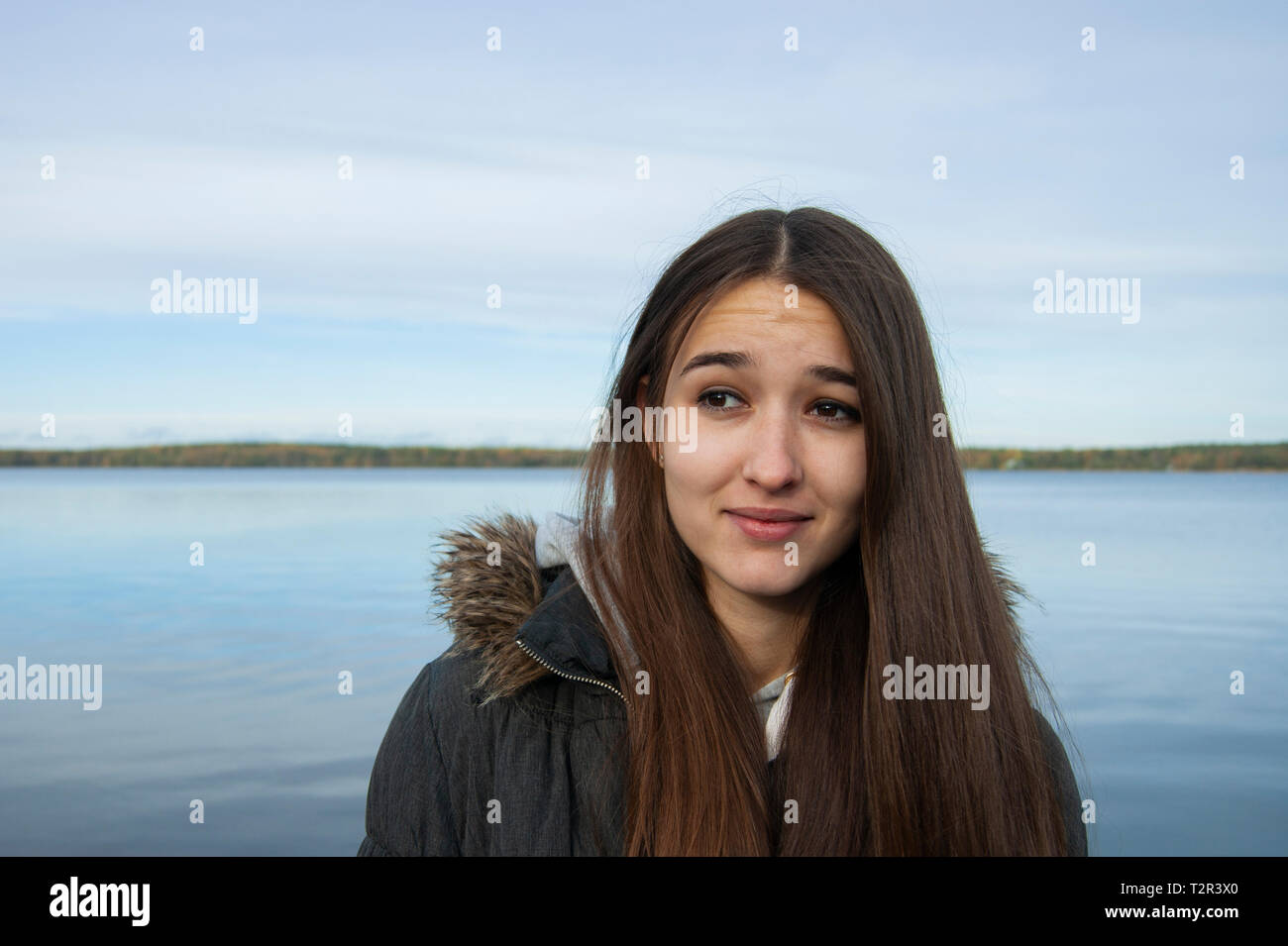 The girl on the background of the lake with a strange facial expression ...