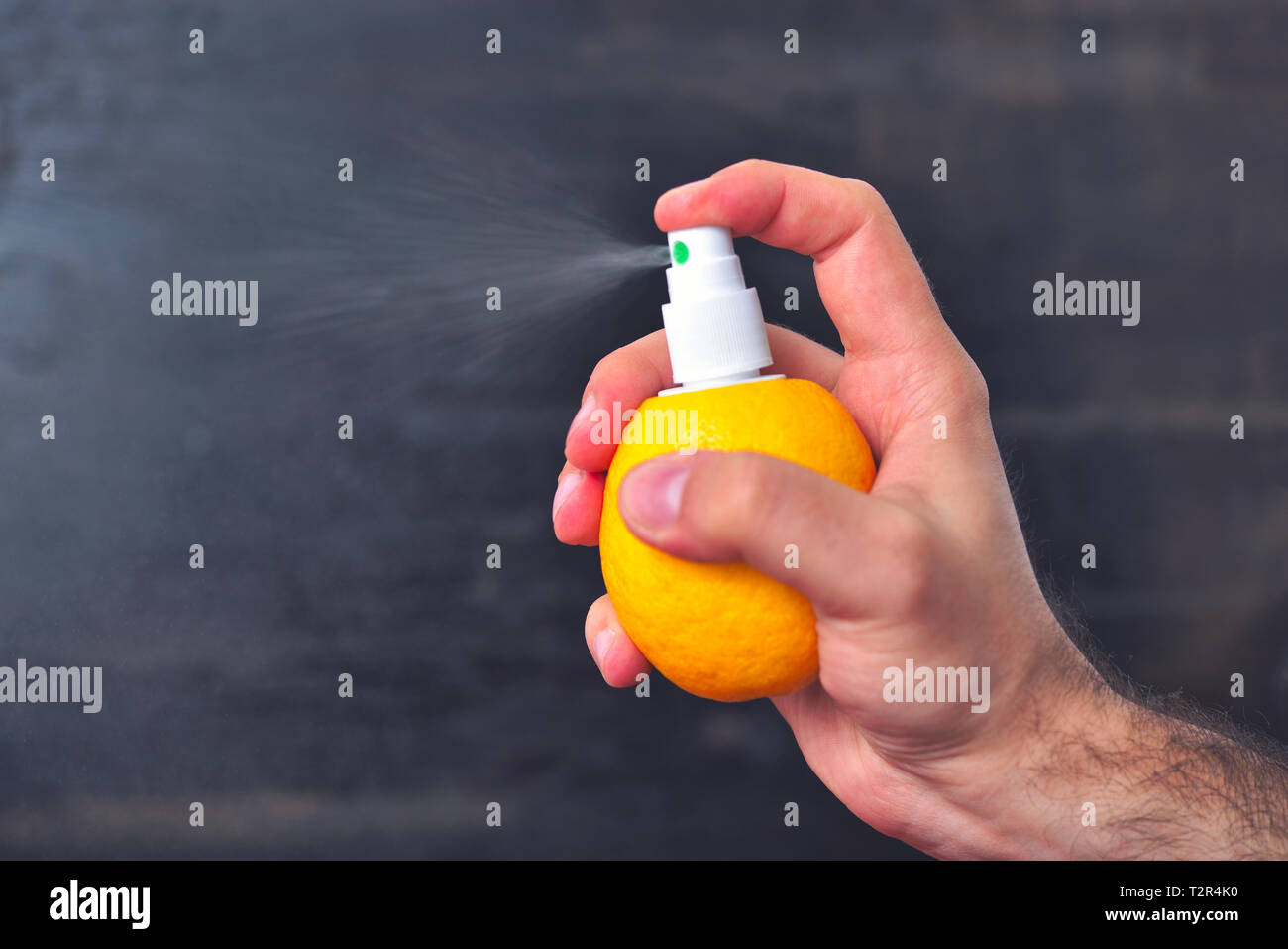 Man sprinkles juice from lemon with help of pump for spray. Healthy ...