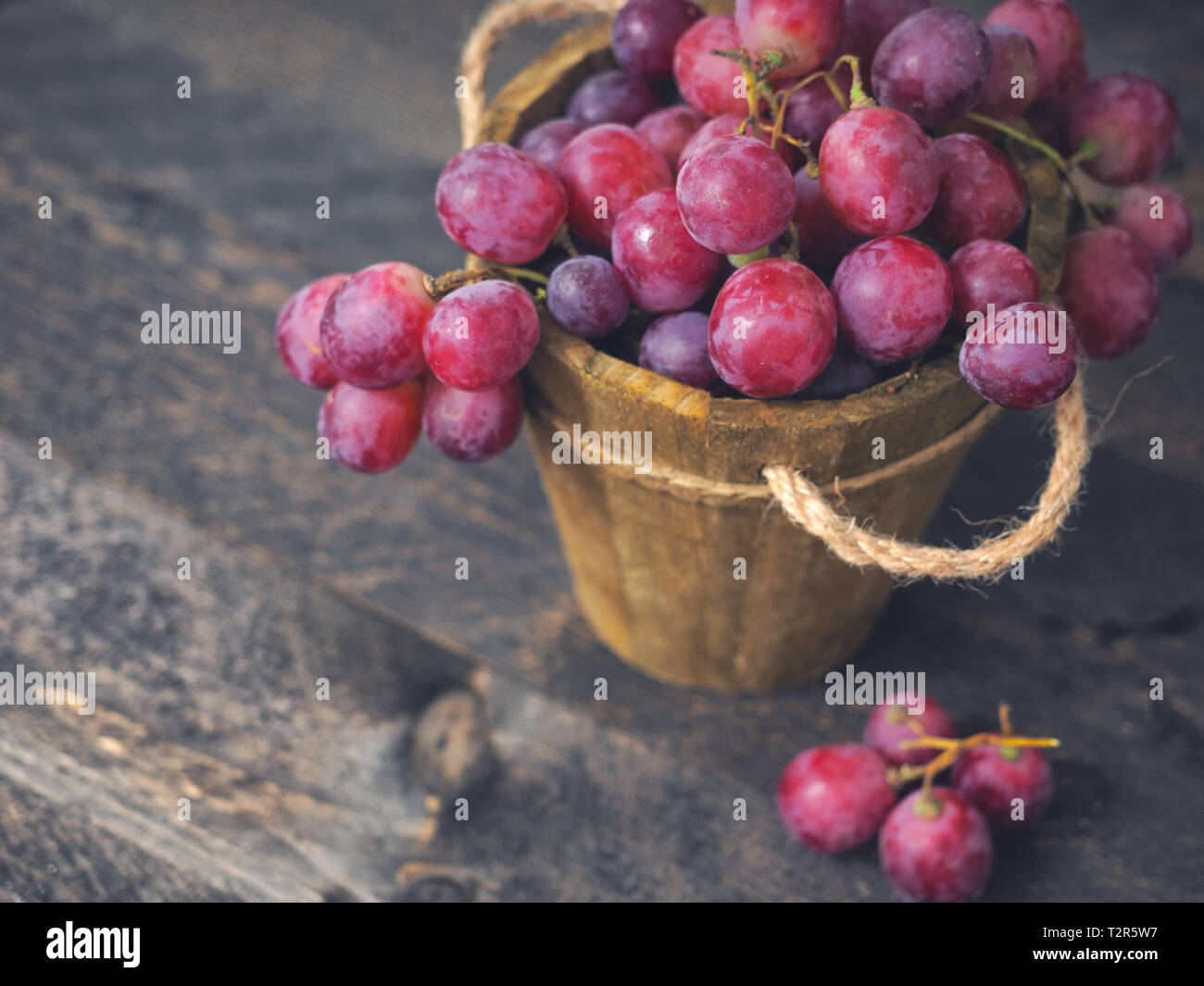 Rose grapes in wooden bucket on a woden table Stock Photo - Alamy