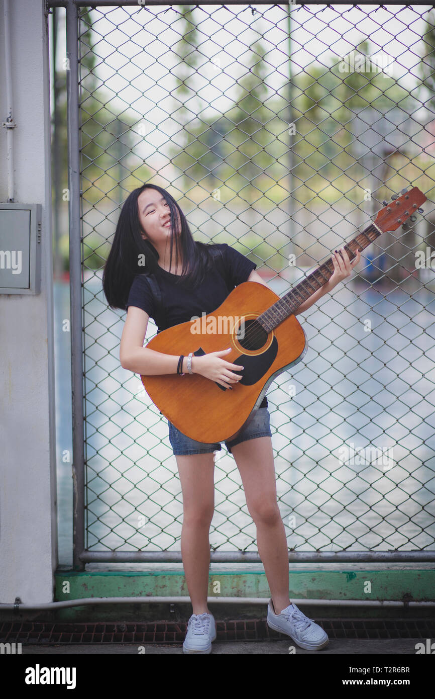asian teenager playing spanish guitar with happiness emotion Stock ...