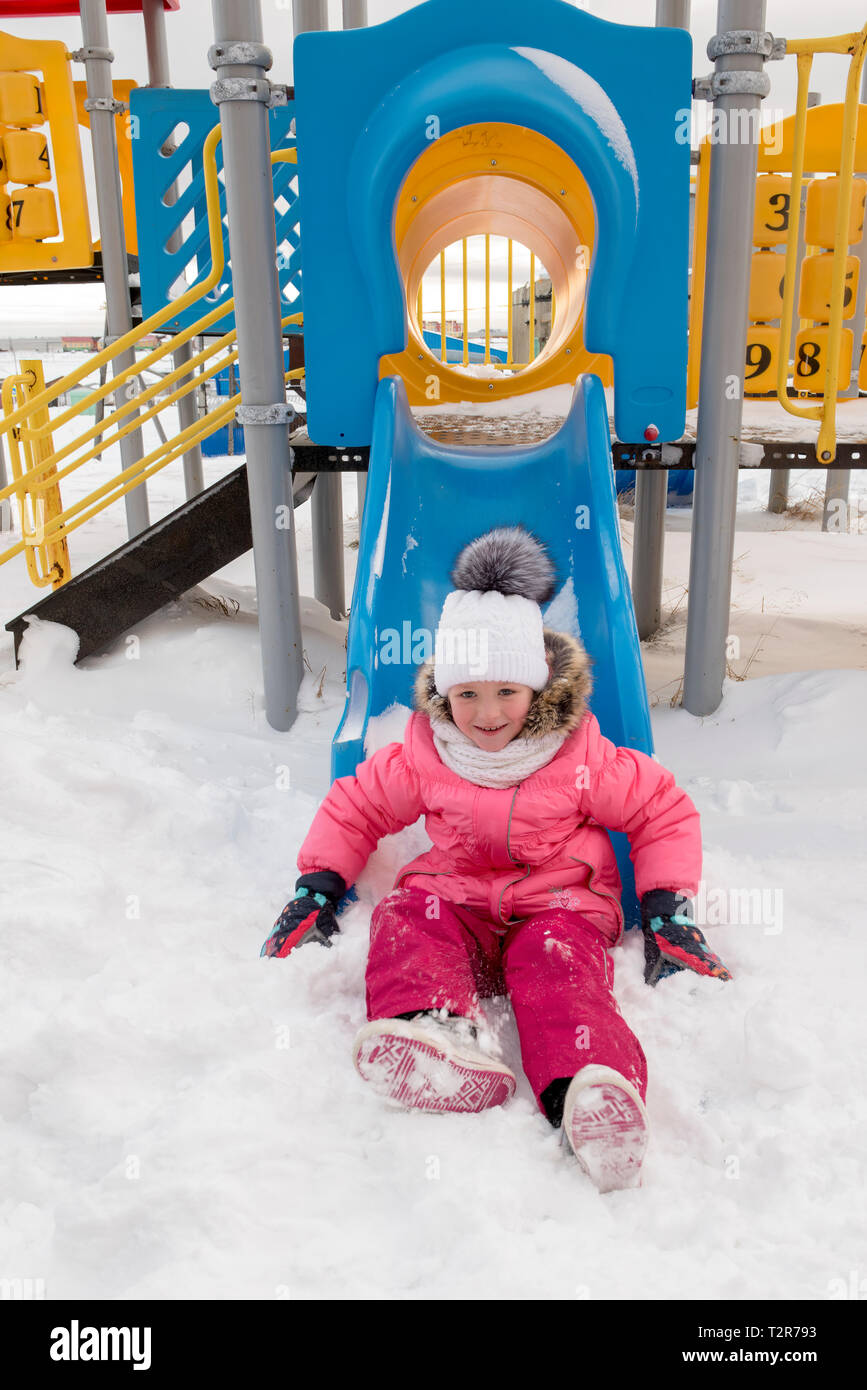 Young girl sliding on the slide in winter Stock Photo - Alamy