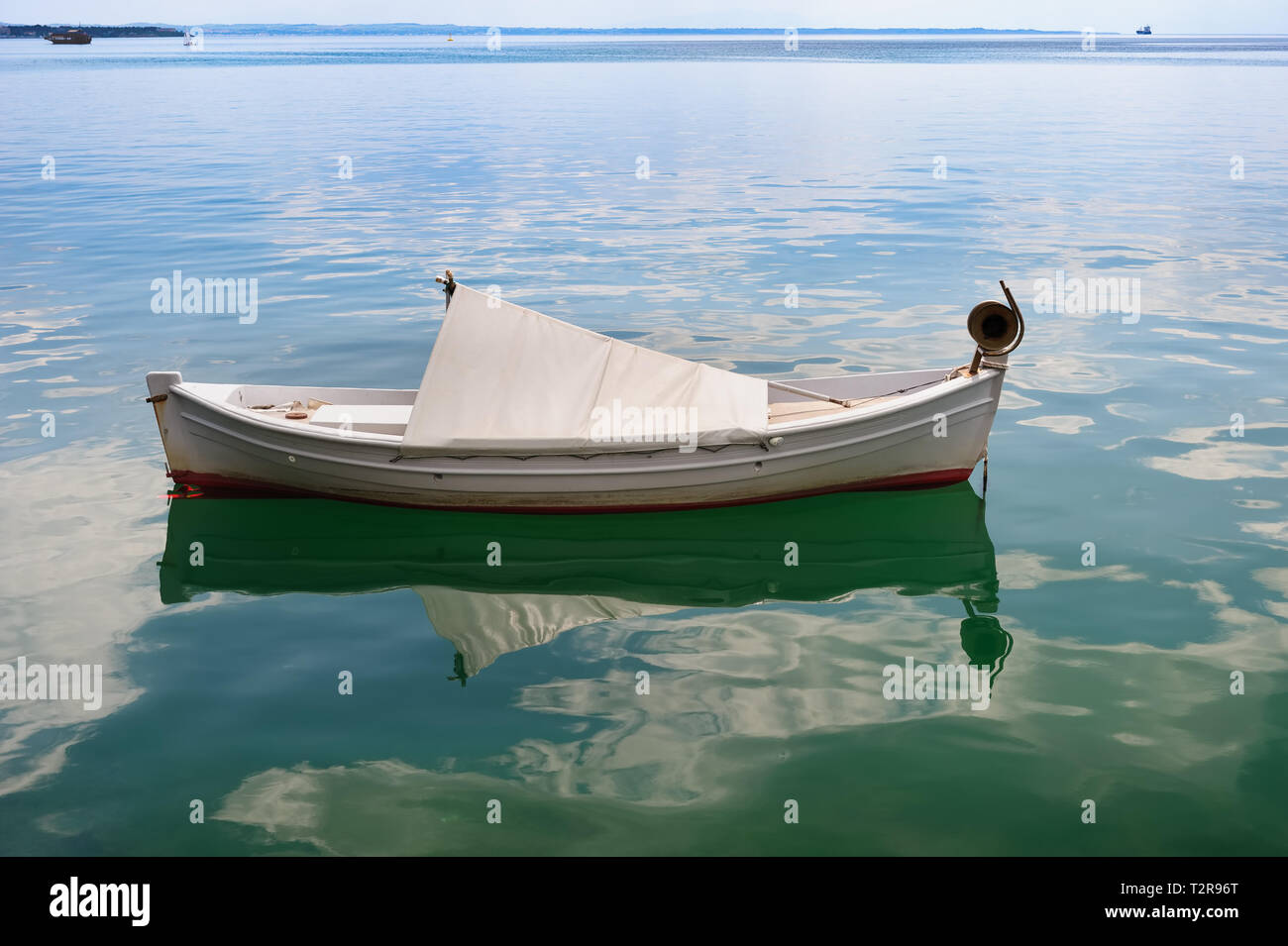 Very small white fishing boat at sea surface Stock Photo - Alamy