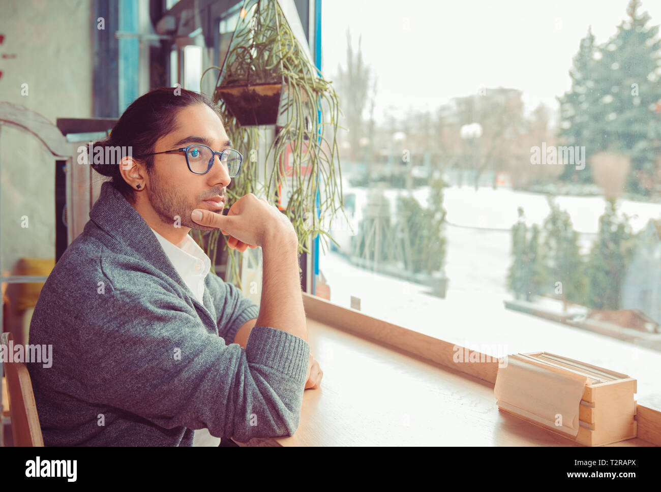 Man in living room looking through window, being thoughtful Stock Photo ...