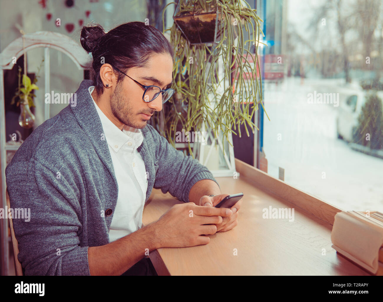 Staying connected. Happy young man looking at his mobile phone. Closeup ...