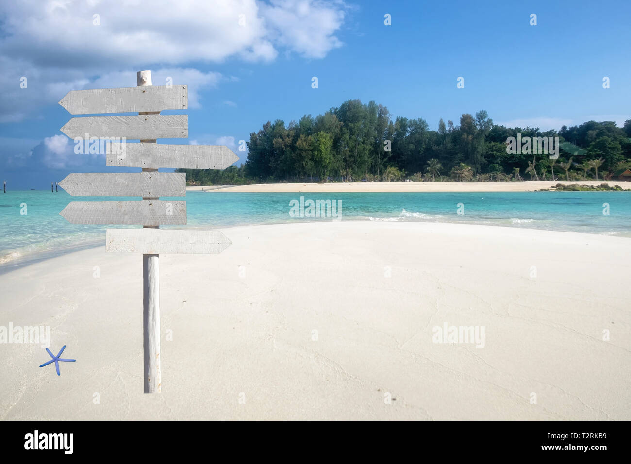 Wooden arrows signboard on beautiful tropical sea with white beach ...