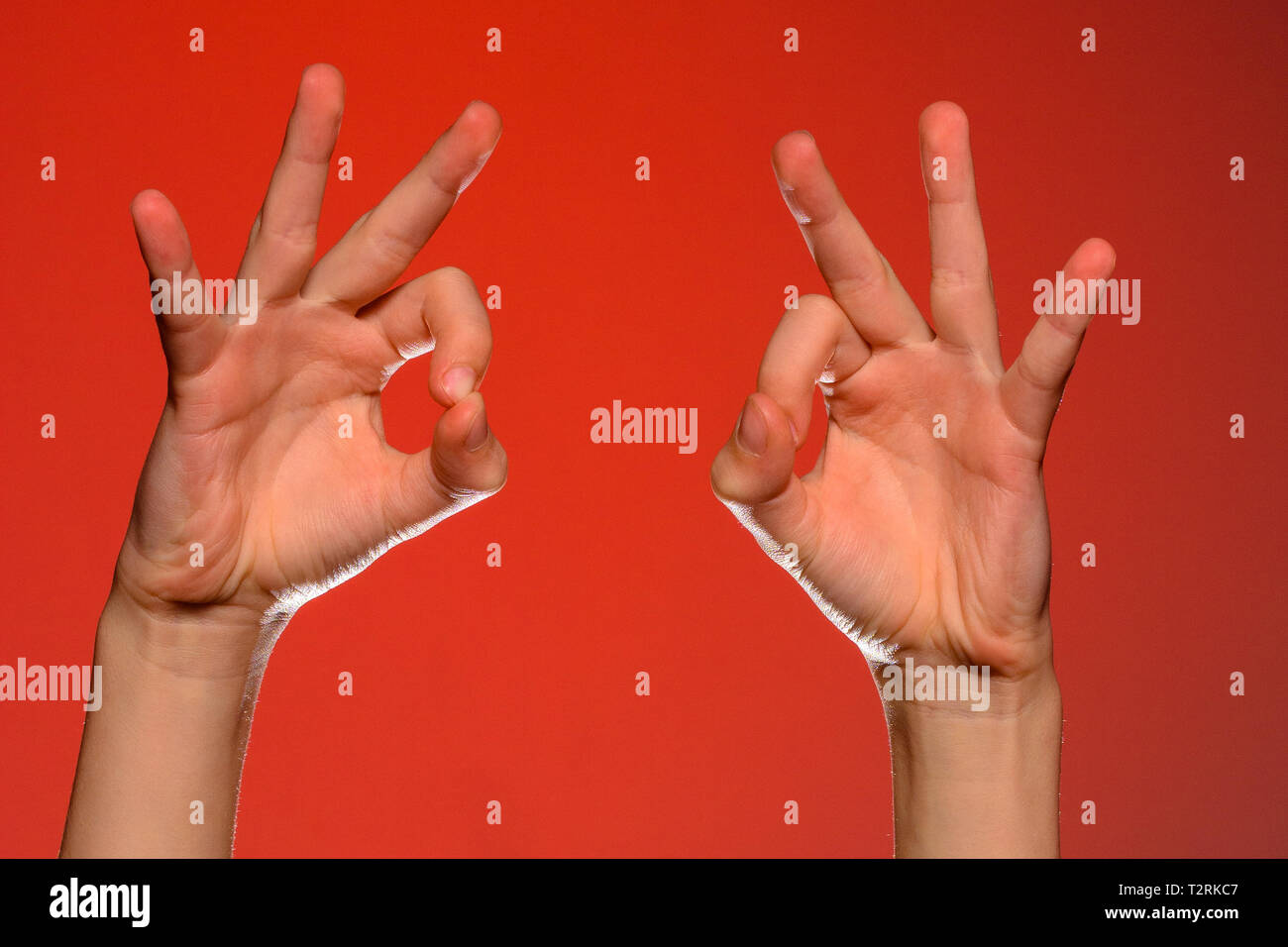 Two human hands show a sign ok, isolated on a red background 2019 Stock ...