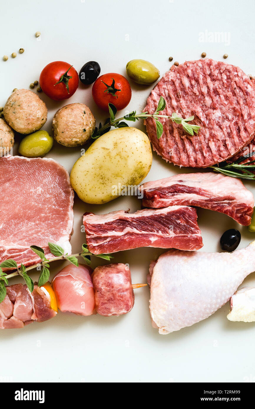 different types of raw meat: chicken thighs, pork and beef burgers ...
