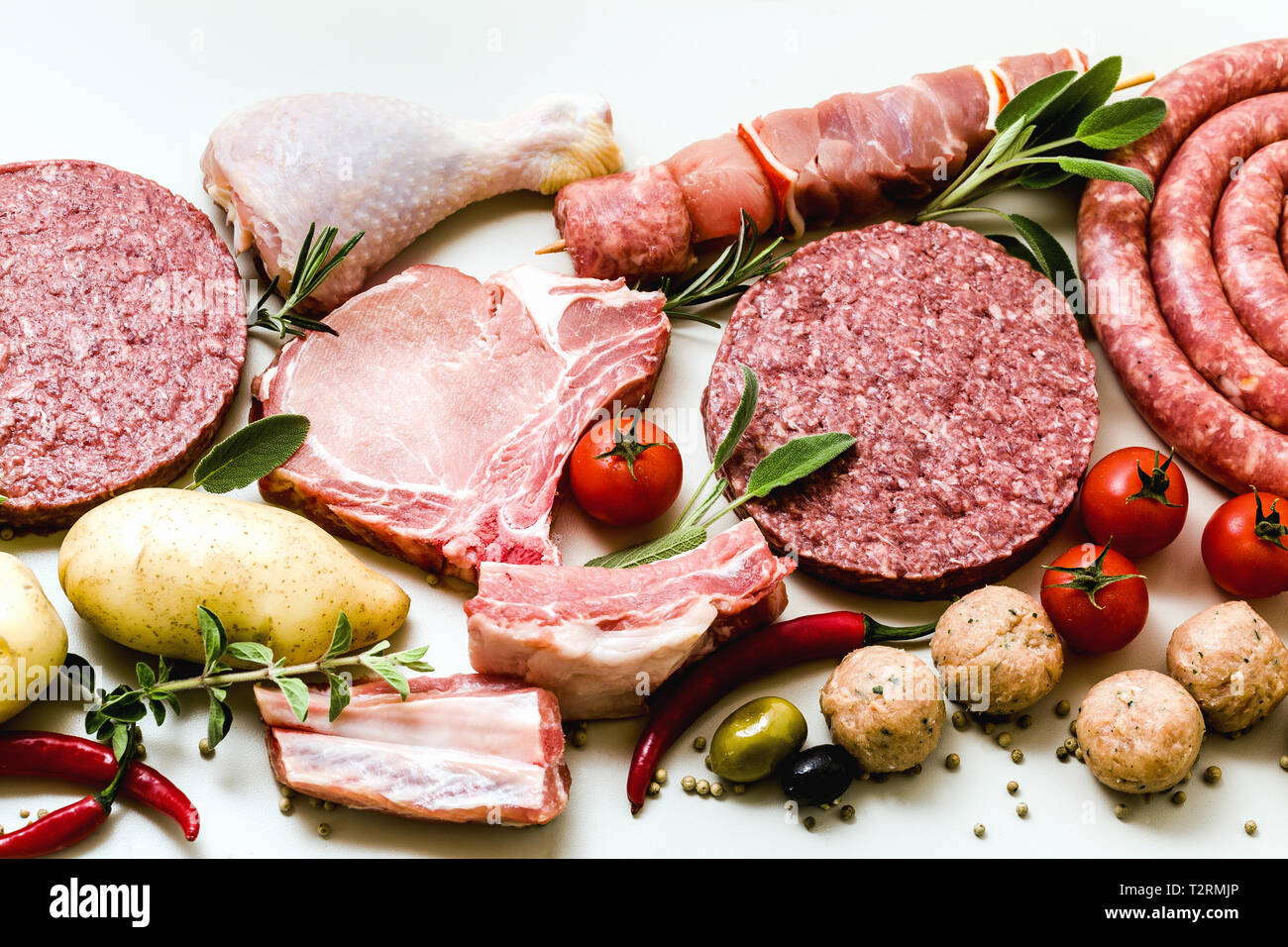 different types of raw meat: chicken thighs, pork and beef burgers ...
