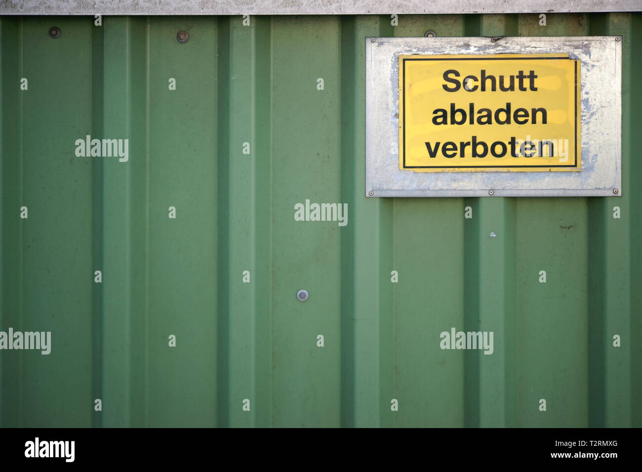A metal container wall with a warning sign with inscription: Dump ...