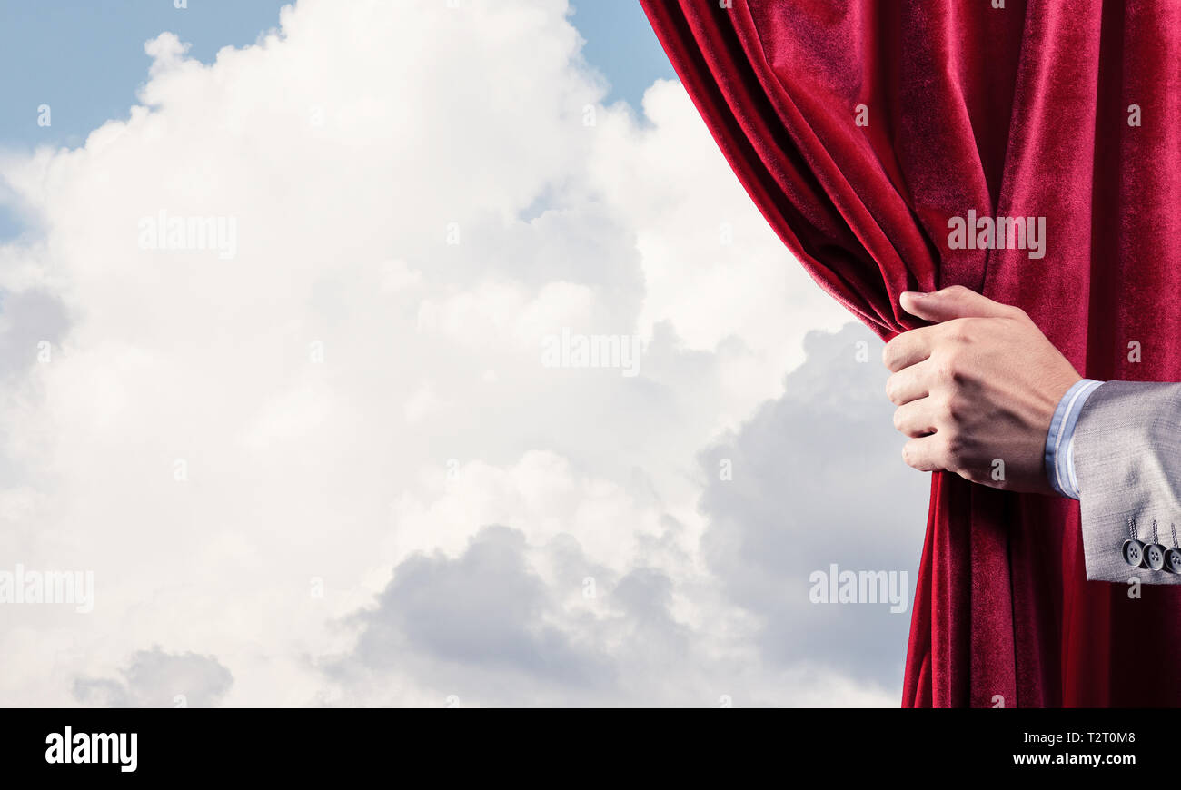 Human hand opens red velvet curtain on blue sky background Stock Photo ...