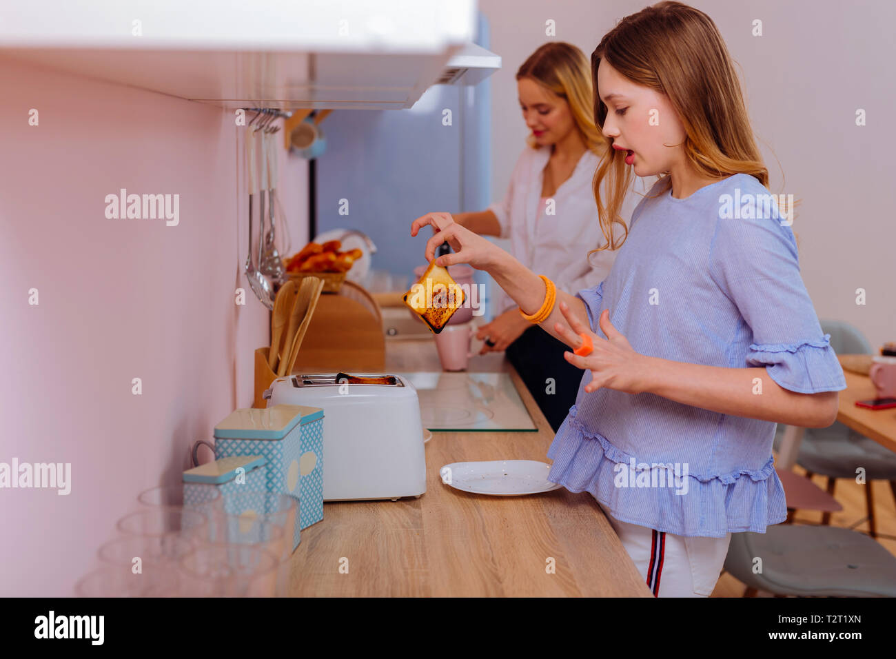 Hot toast. Teenage sister wearing blue blouse and orange bracelet ...