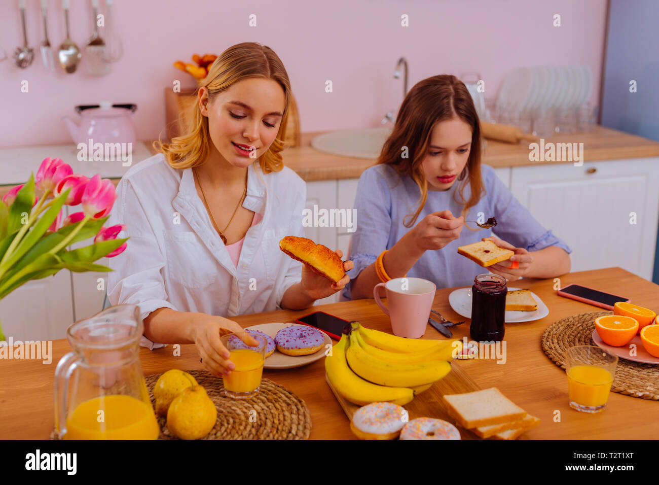 Breakfast with sibling. Beautiful older blonde sister eating yummy ...