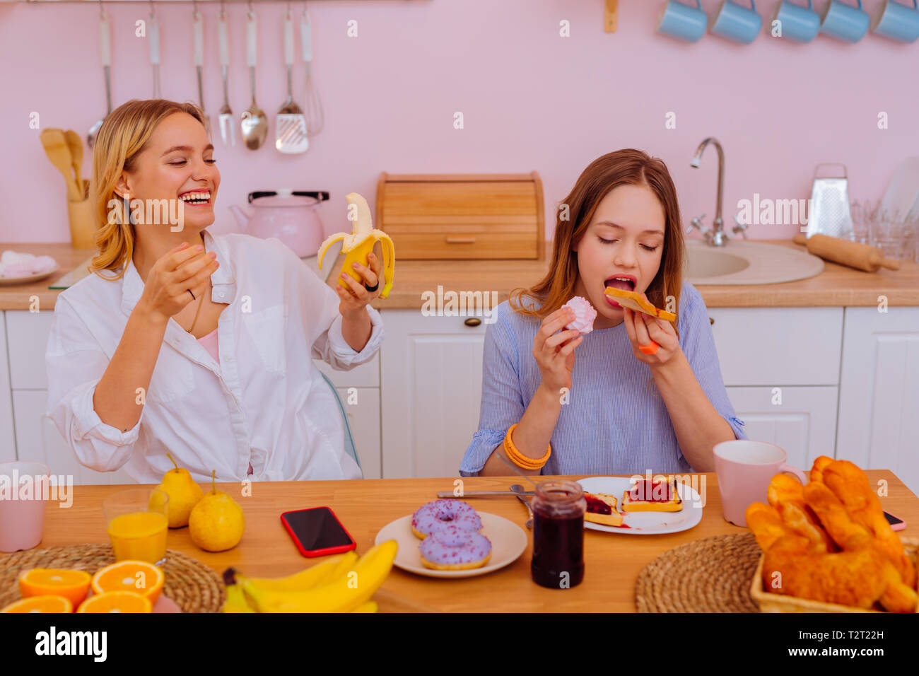 Too much sweets. Older sister laughing while watching her teenage ...