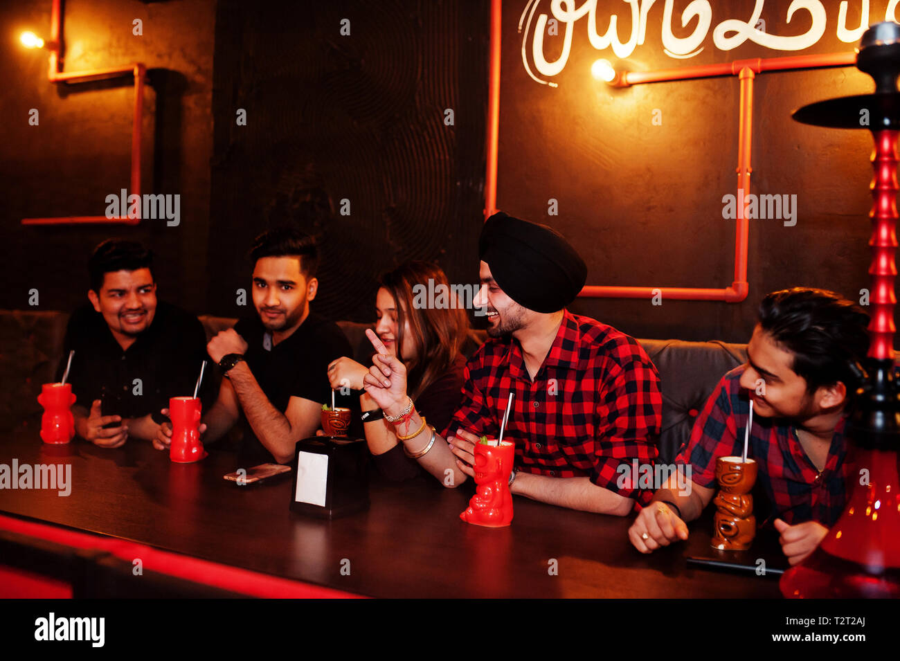 Group of indian friends having fun and rest at night club, drinking ...