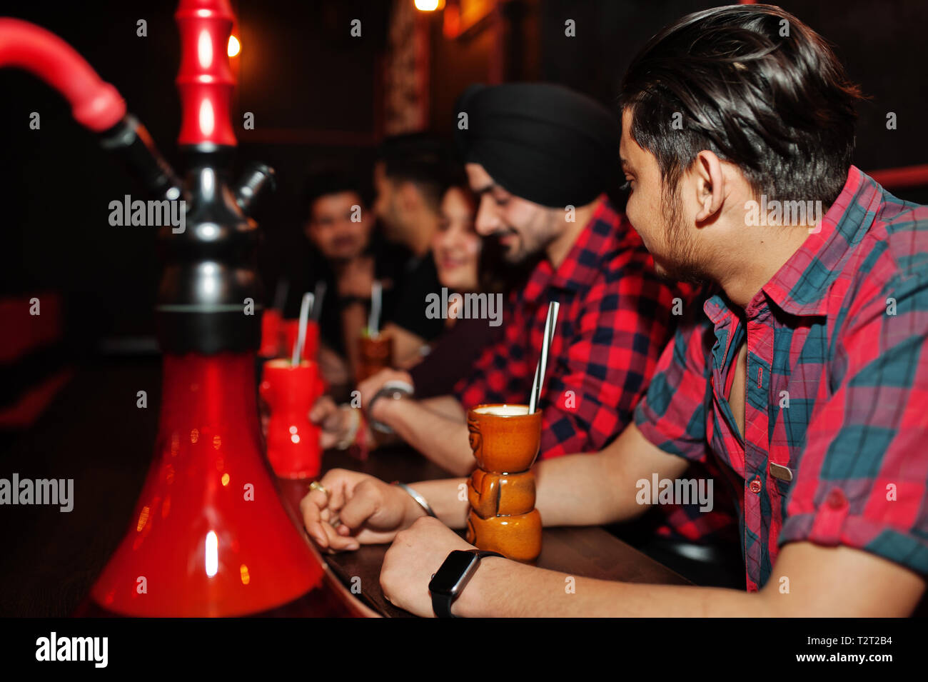Group of indian friends having fun and rest at night club, drinking ...