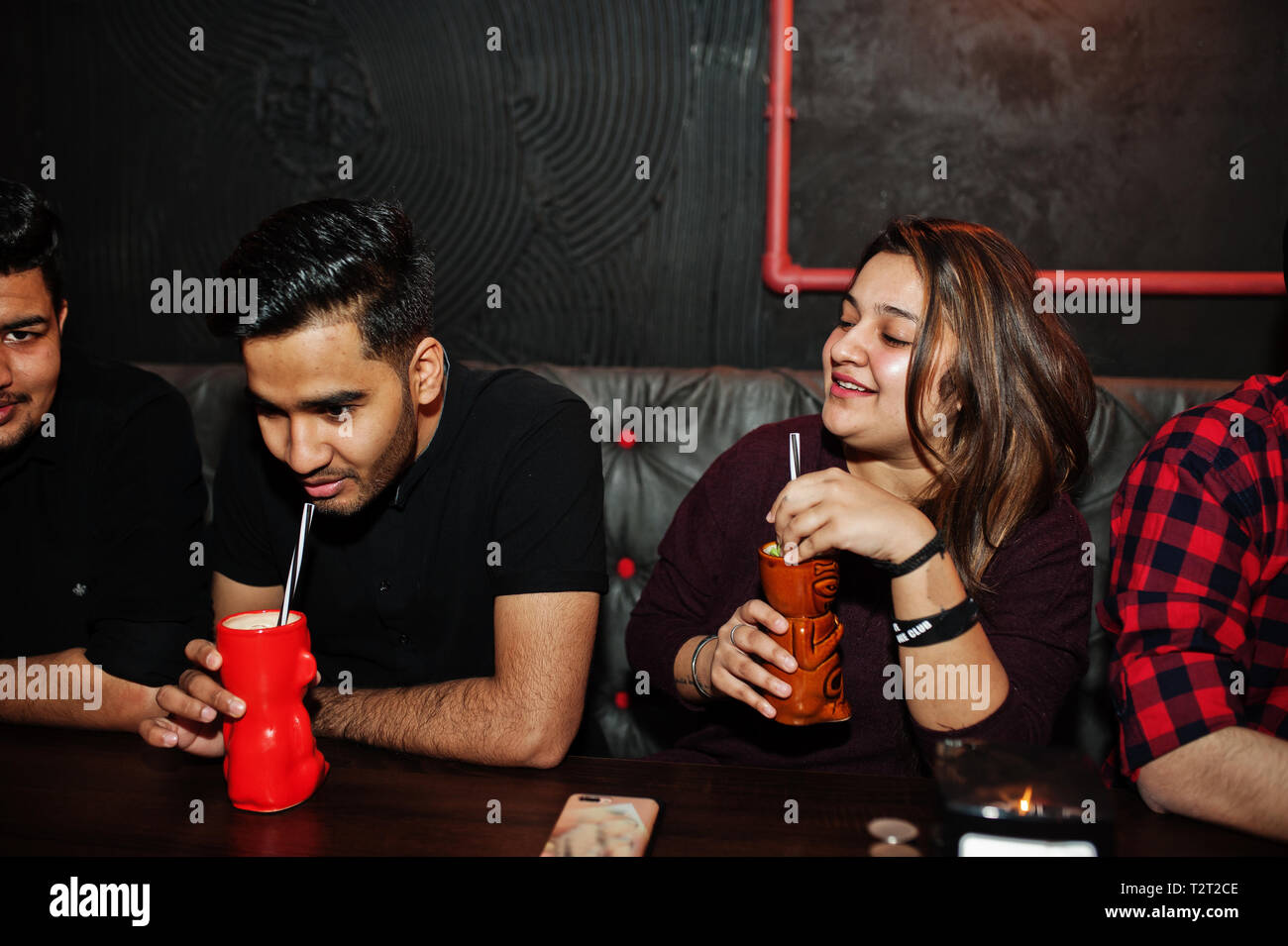 Group of indian friends having fun and rest at night club, drinking ...