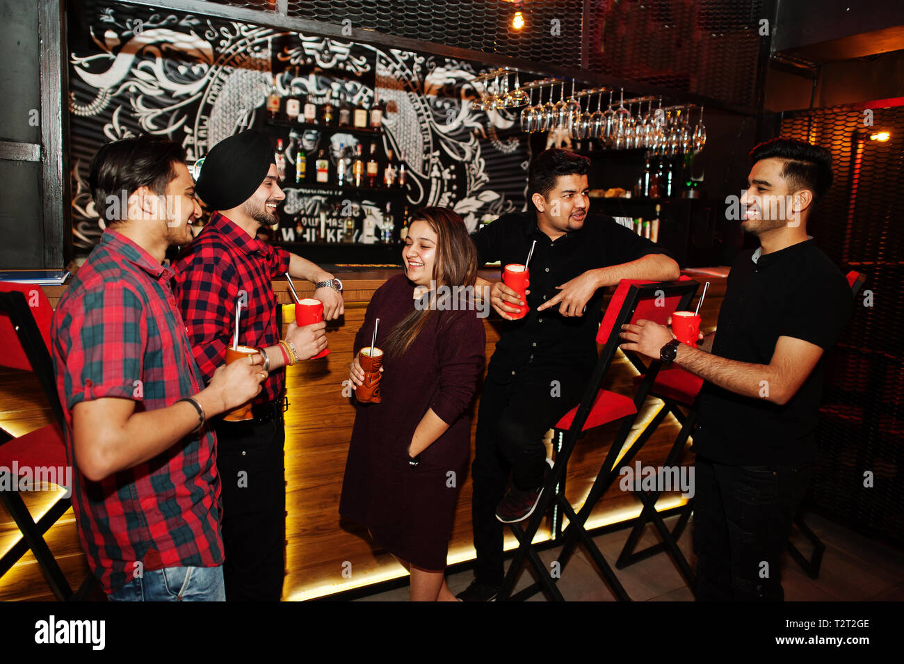 Group of indian friends having fun and rest at night club, drinking ...