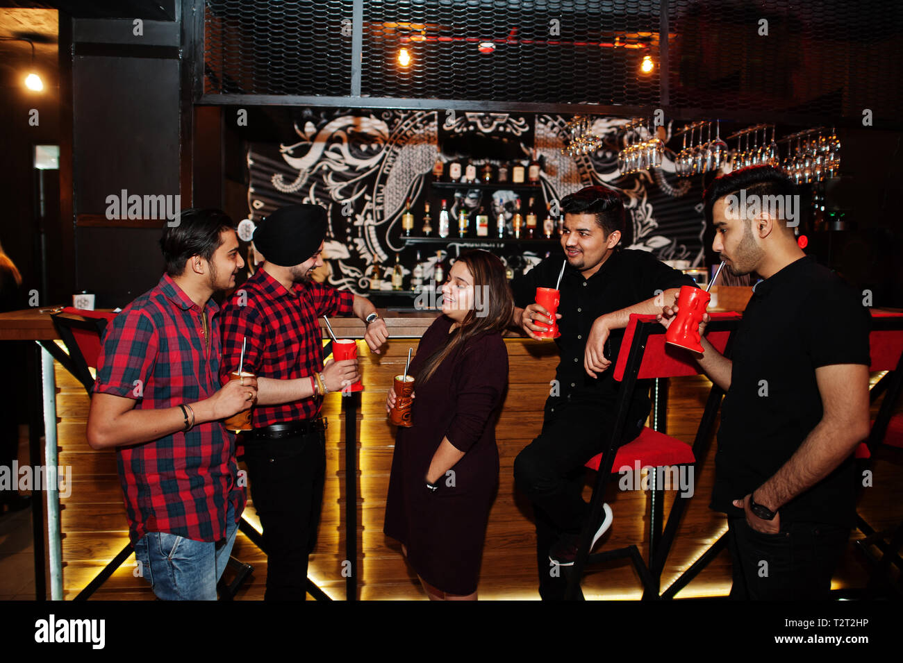 Group of indian friends having fun and rest at night club, drinking ...