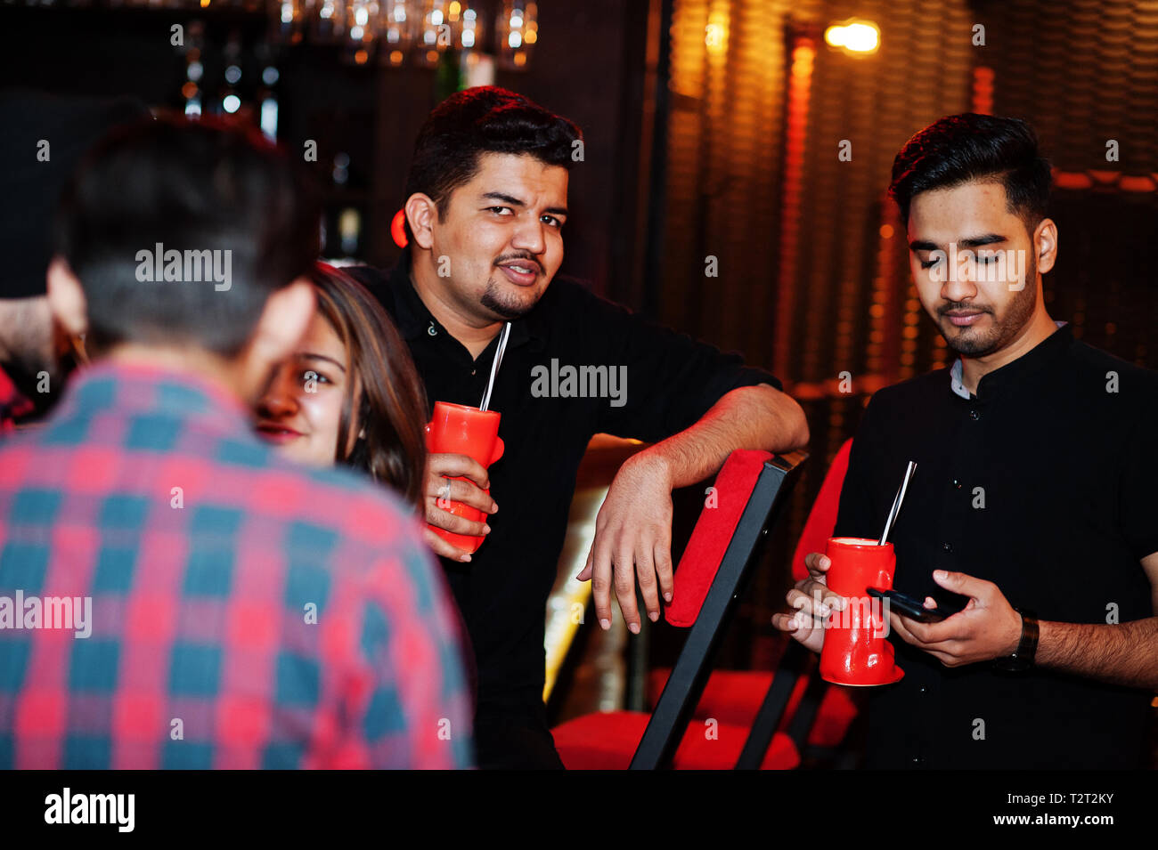 Group of indian friends having fun and rest at night club, drinking ...