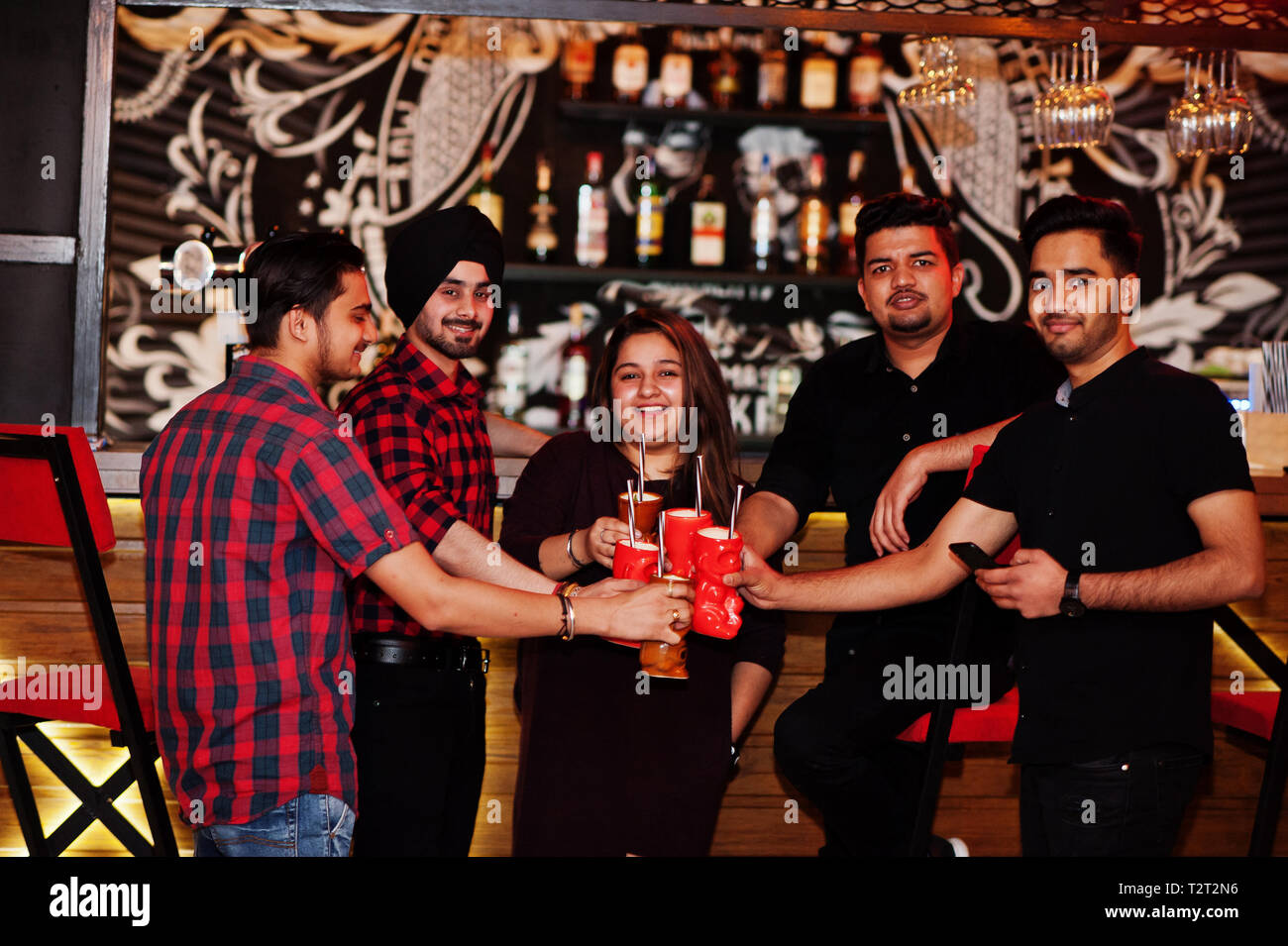 Group of indian friends having fun and rest at night club, drinking ...