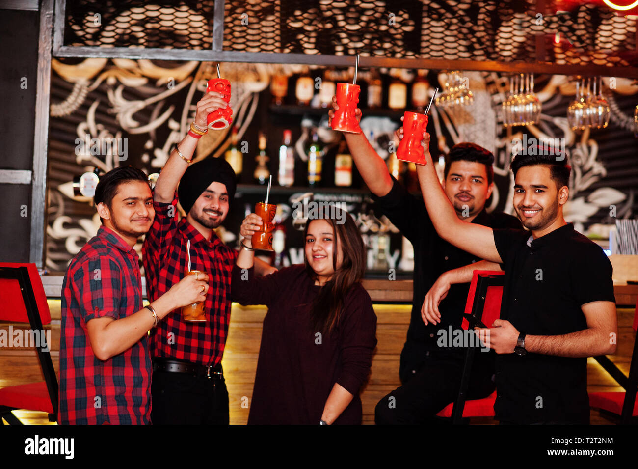 Group of indian friends having fun and rest at night club, drinking ...