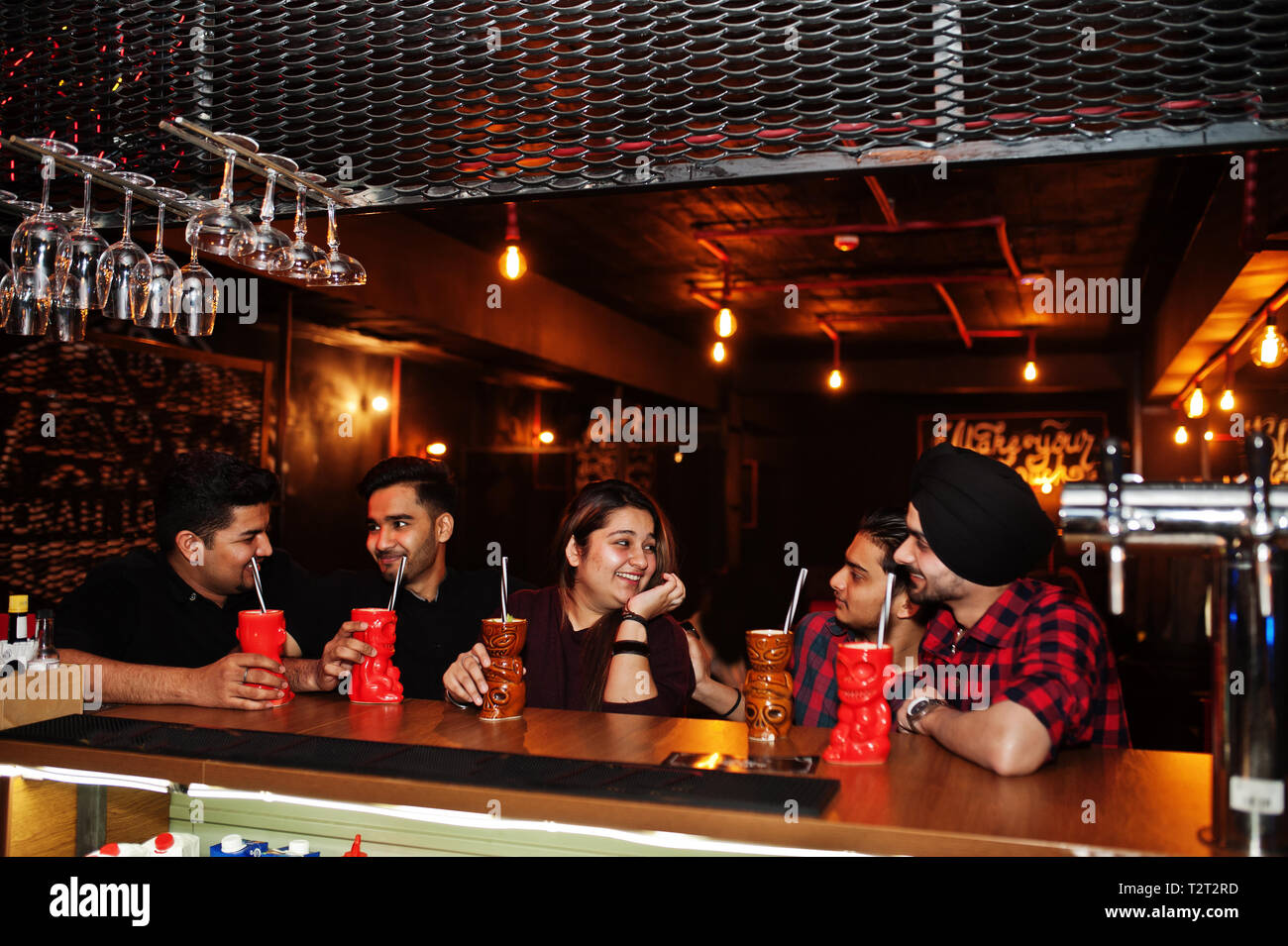 Group of indian friends having fun and rest at night club, drinking ...