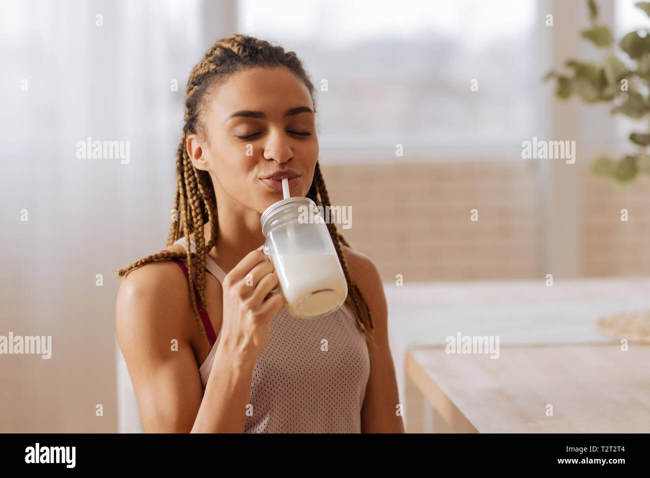 Healthy milk shake. Woman with nice hairstyle feeling good drinking ...