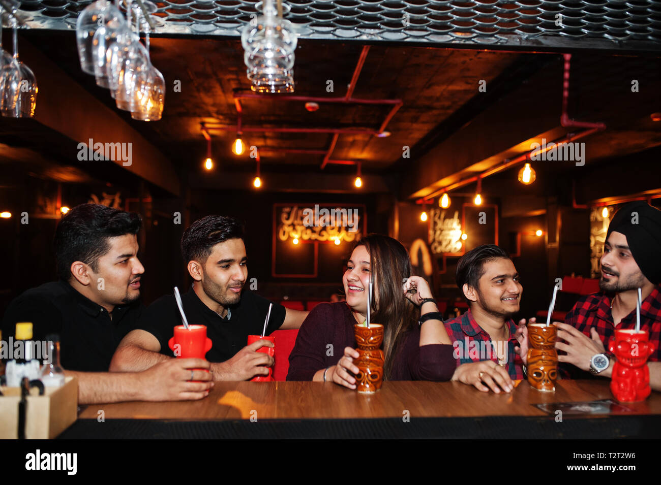 Group of indian friends having fun and rest at night club, drinking ...