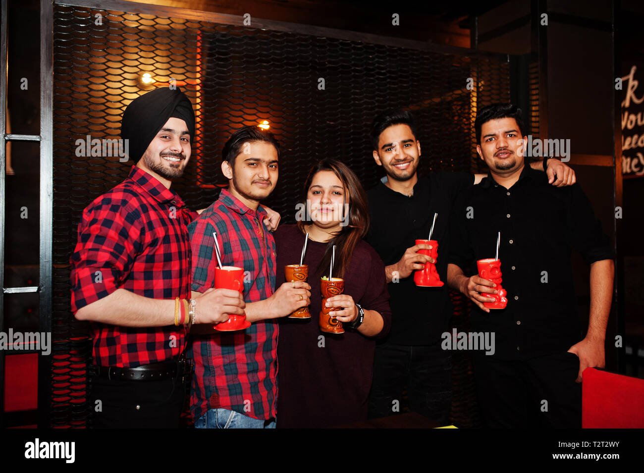Group of indian friends having fun and rest at night club, drinking ...