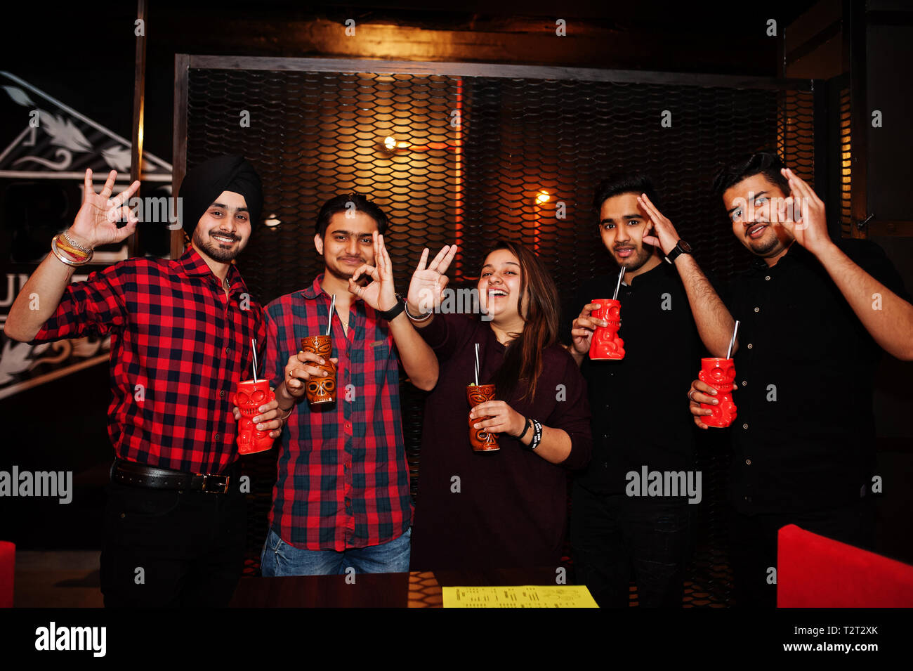 Group of indian friends having fun and rest at night club, drinking ...