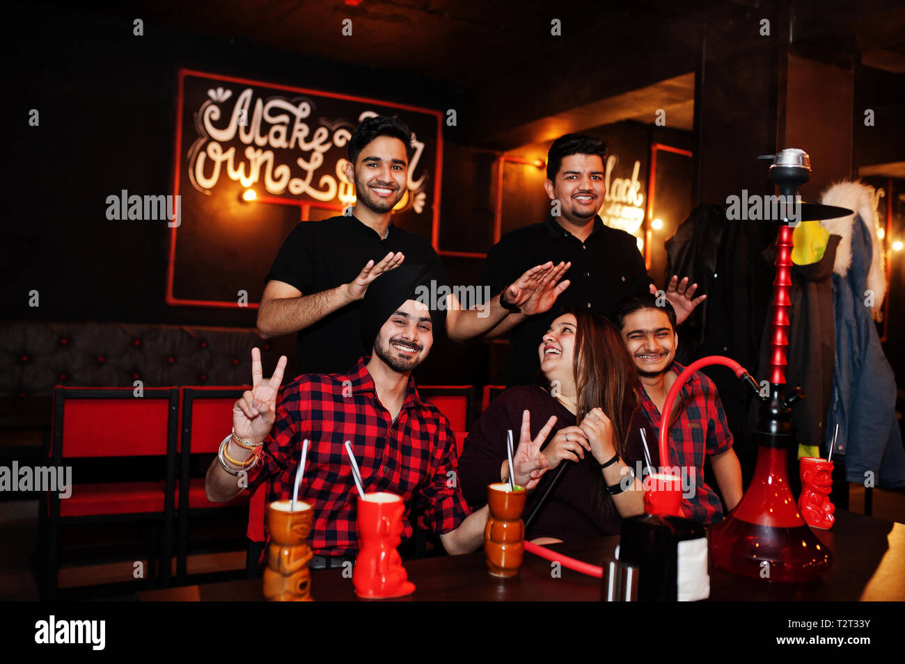 Group of indian friends having fun and rest at night club, drinking ...