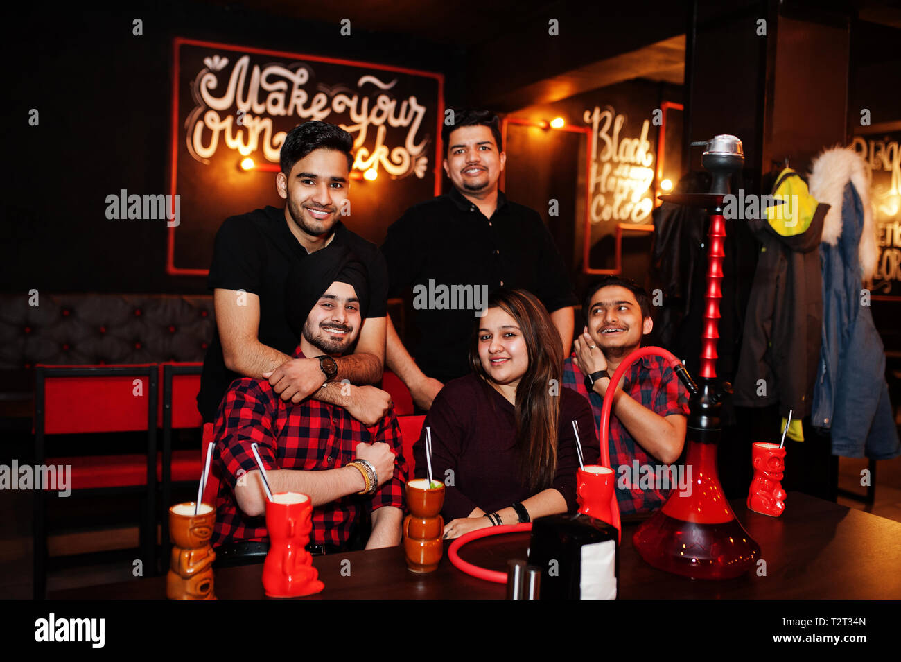 Group of indian friends having fun and rest at night club, drinking ...