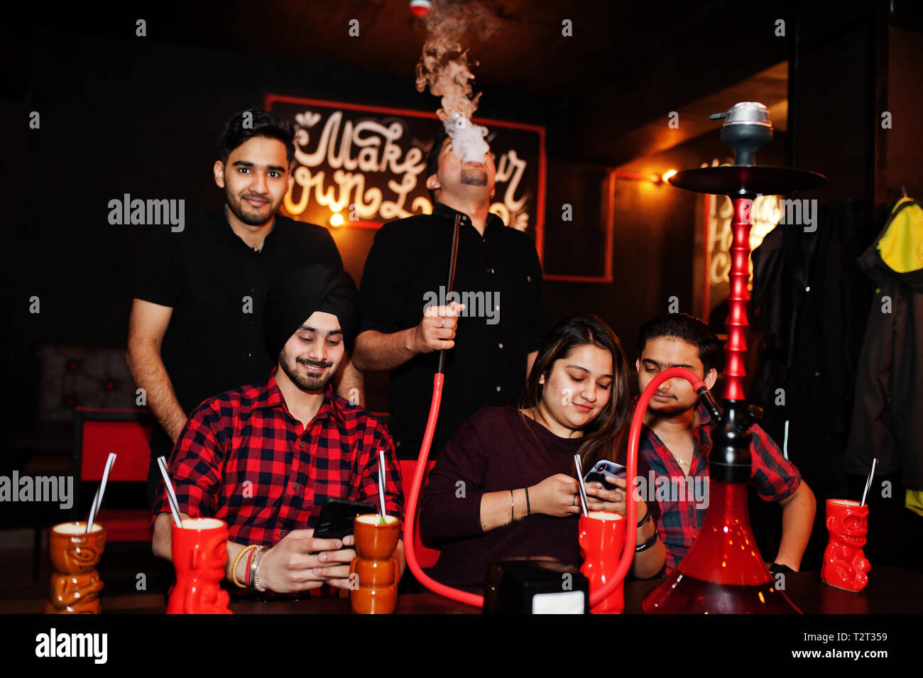 Group of indian friends having fun and rest at night club, drinking ...
