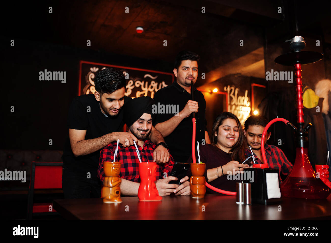 Group of indian friends having fun and rest at night club, drinking ...